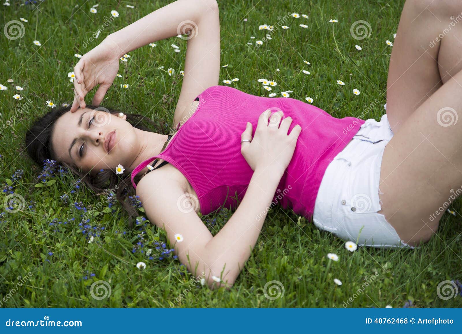 Attractive Young Woman Laying Down In Grassland Casual Dress Stock