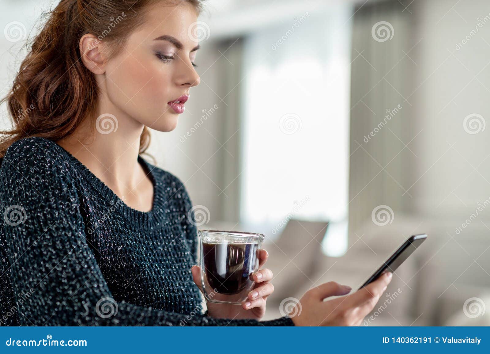 Attractive Young Woman Looking at Her Smart Phone at Home Stock Image ...
