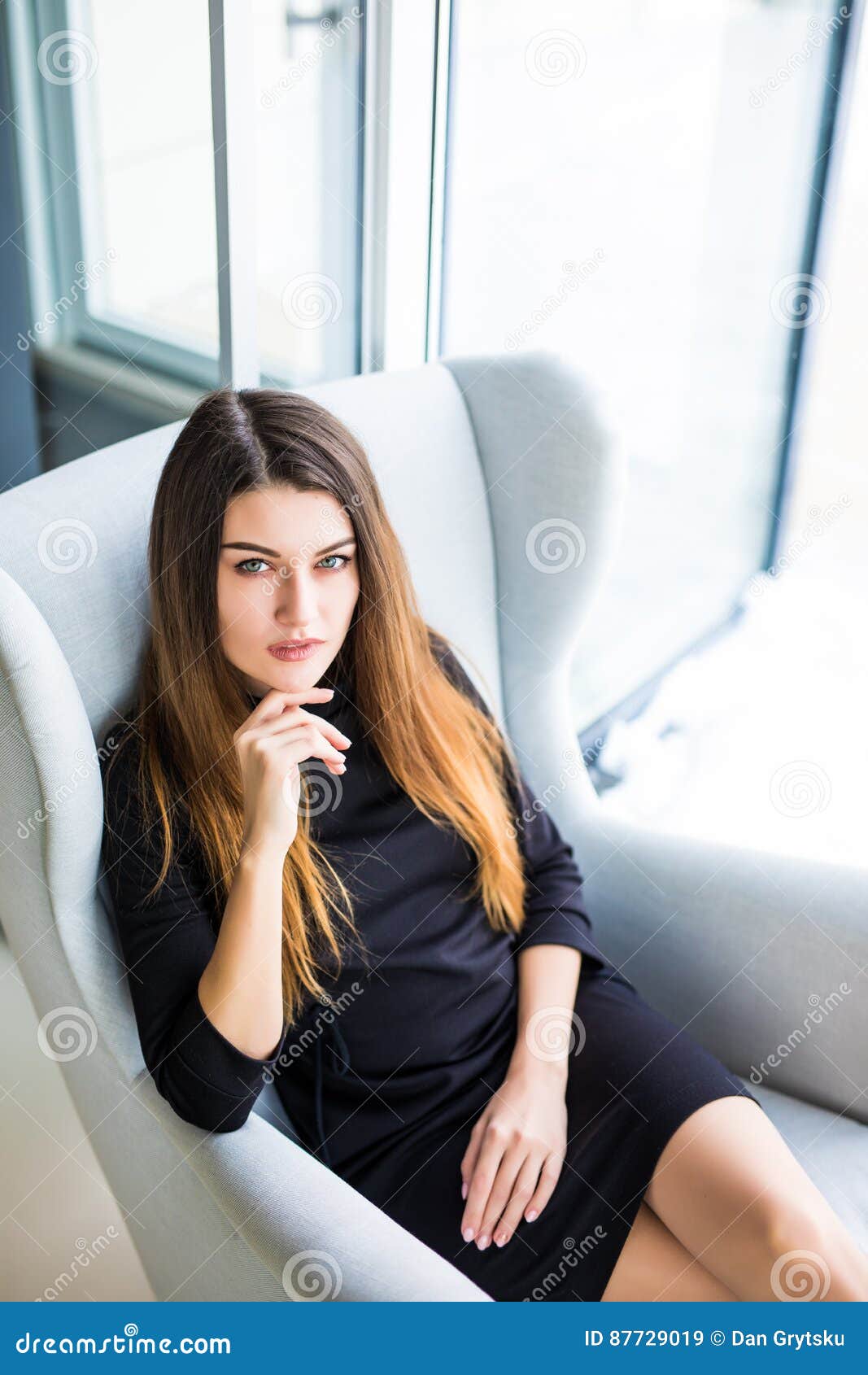 Attractive Young Woman Sitting On A Chair While Working In A Cafe Stock