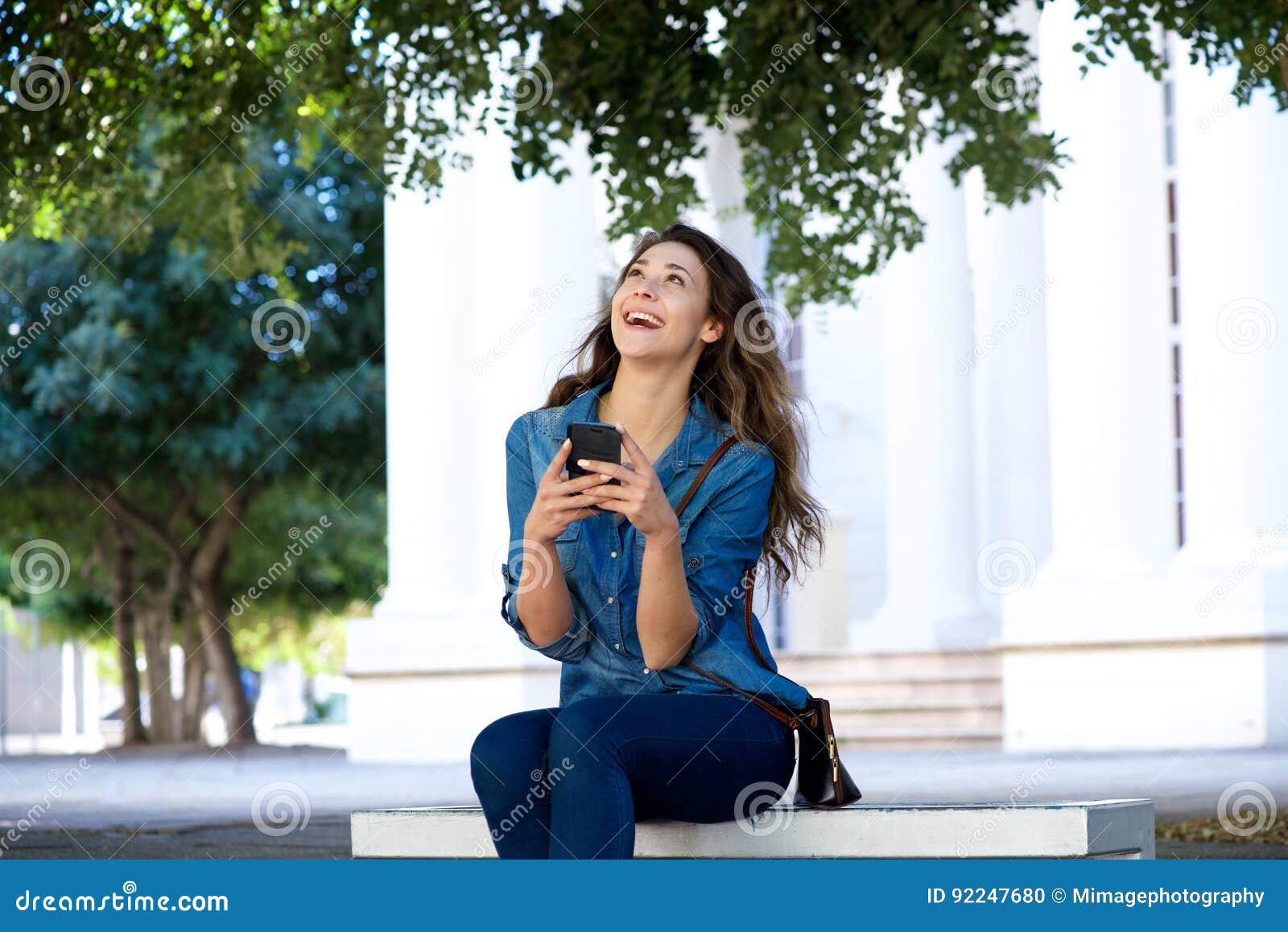 Attractive Young Woman Smiling Outside and Holding Cellphone Stock ... Attractive Young Woman Smiling Outside and Holding Cellphone Stock ...