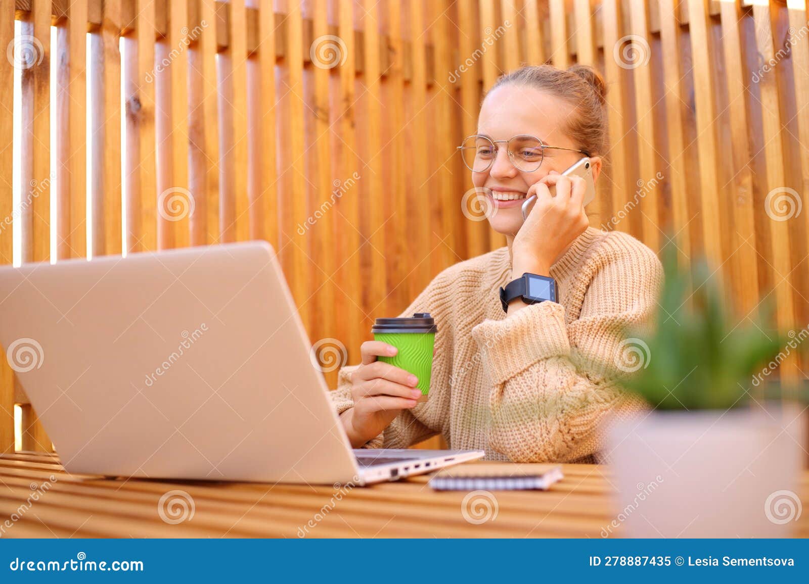 Attractive Young Woman Wearing Beige Sweater Sitting In Outdoor Cafe