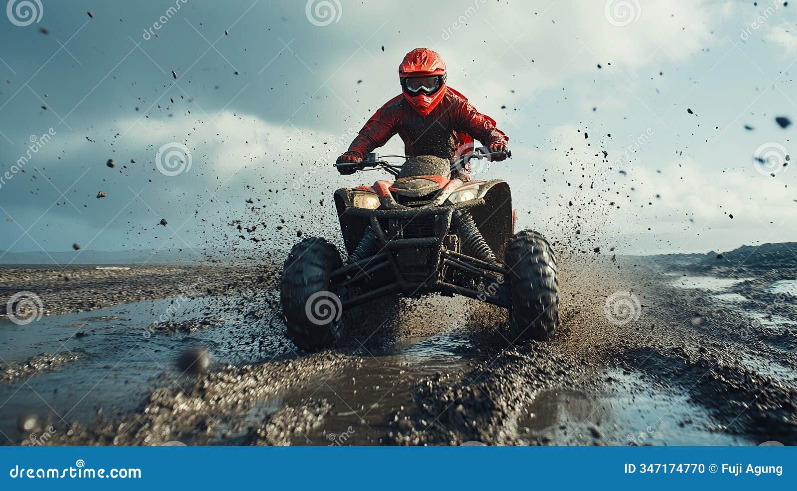 ATV Rider Splashing through Mud Puddle on a Dirt Road Stock ...