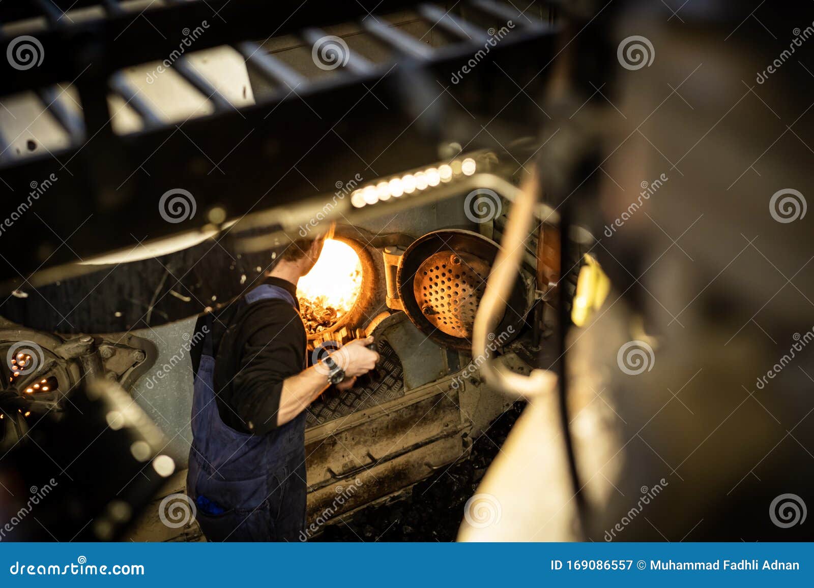 A Worker Insert A Coal Inside The Engine Of Coaled Power Steam Ship ...