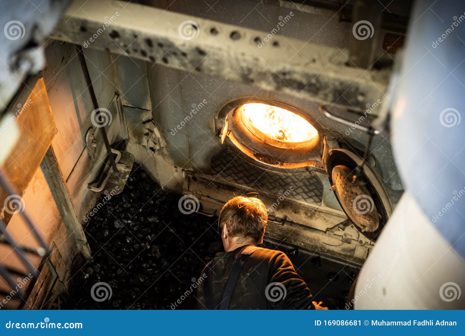 A Worker Insert A Coal Inside The Engine Of Coaled Power Steam Ship ...