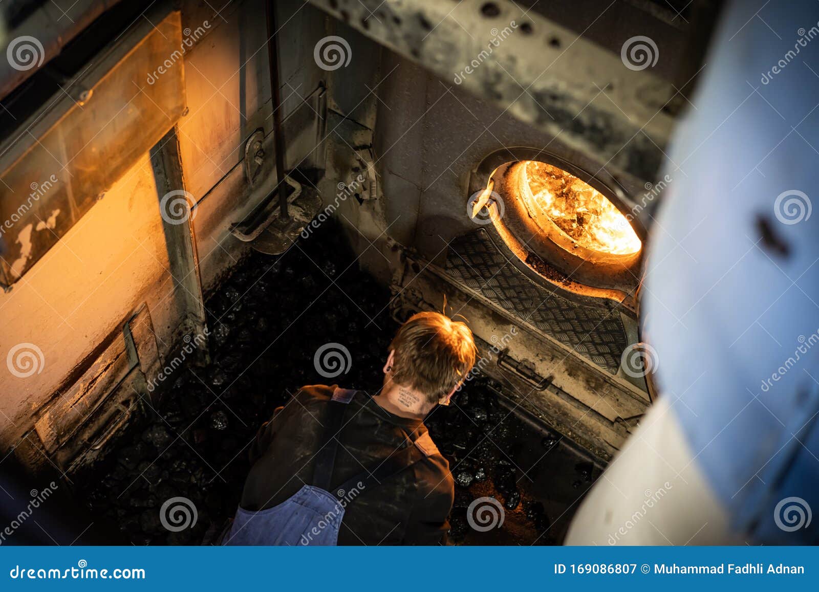 A Worker Insert A Coal Inside The Engine Of Coaled Power Steam Ship ...