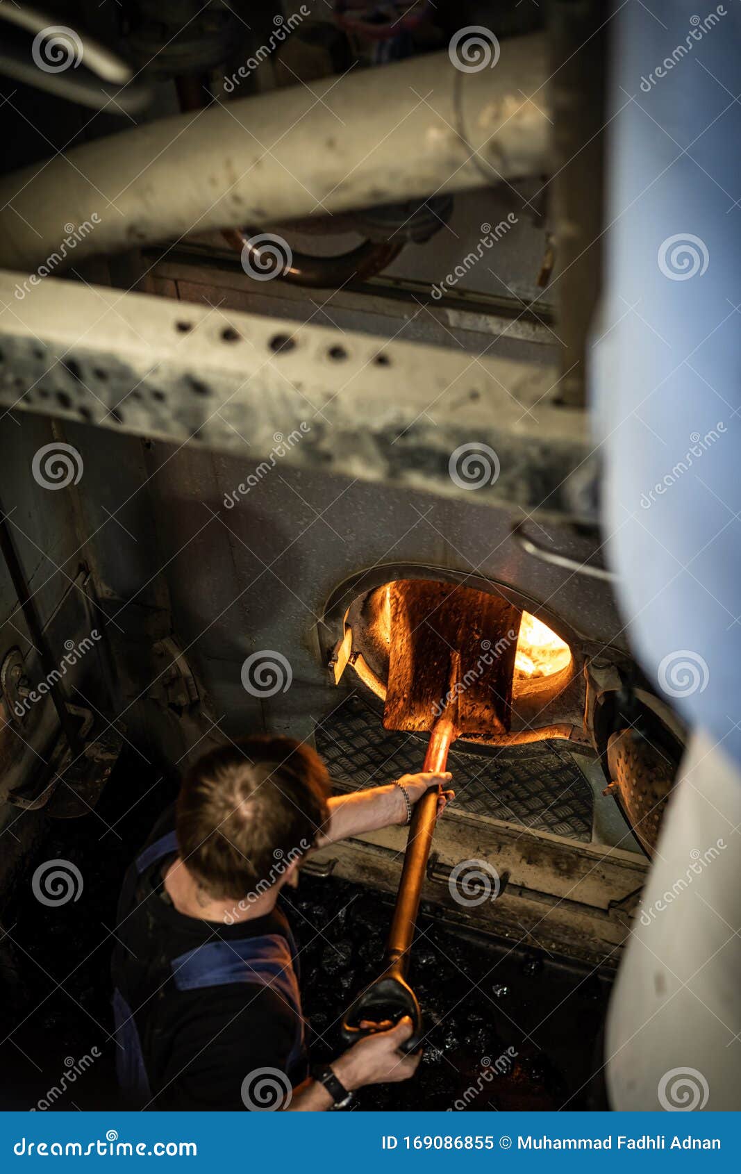 A Worker Insert a Coal Inside the Engine of Coaled Power Steam Ship ...