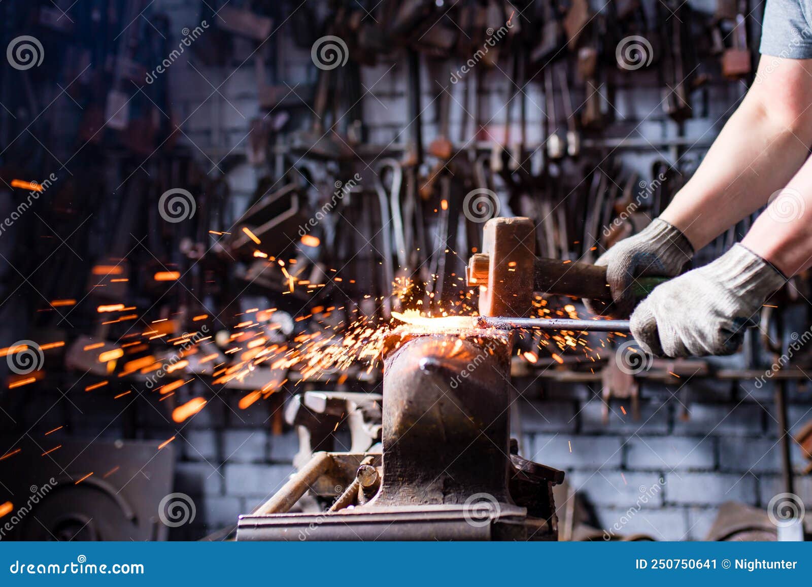Authentic Blacksmith Man Forges a Metal Product in Dark Indoors Studio ...