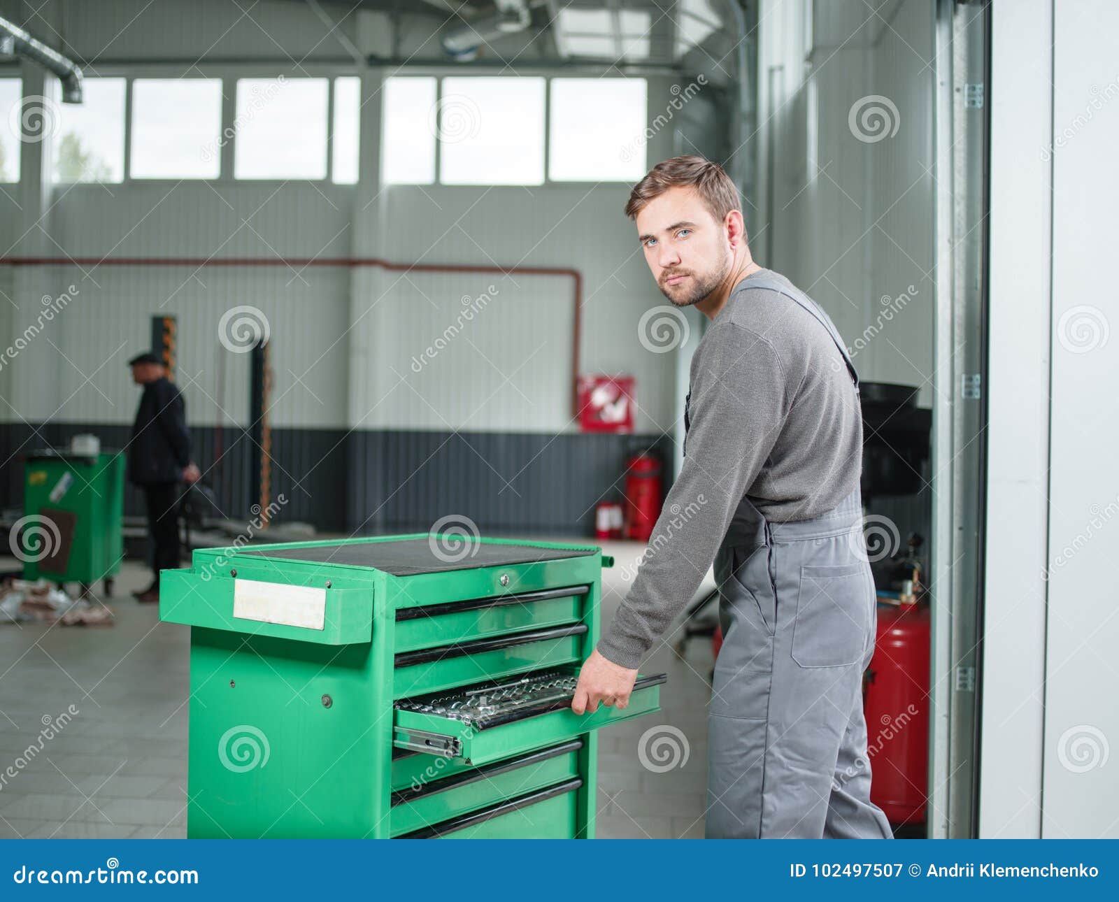 The Auto Mechanic Takes the Tool from the Green Tool Box. Indoors ...