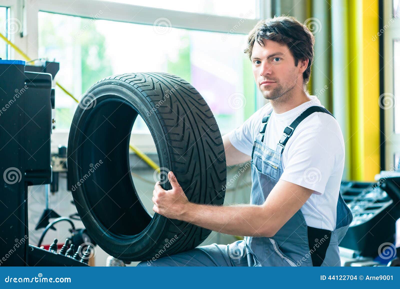 Auto Mechanic Changing Tire in Workshop Stock Photo - Image of handsome ...