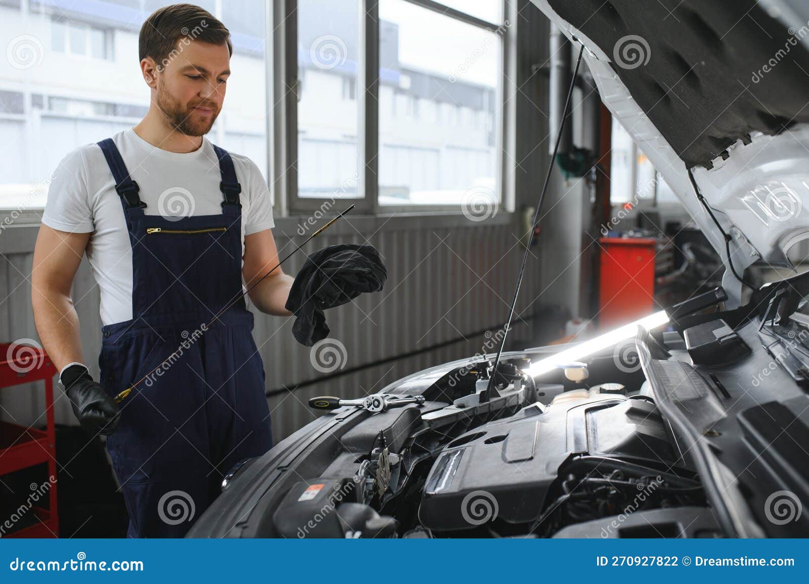 Auto Mechanic Checking The Oil Level In Car Engine,inspects Engine ...