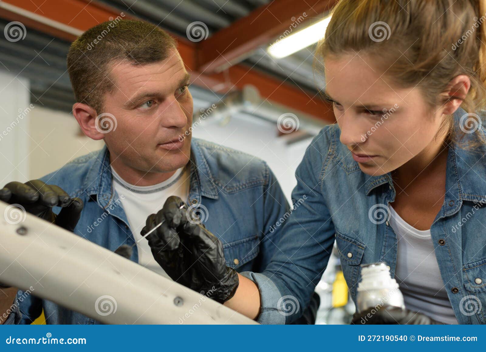 Auto Mechanic Guiding Female Trainee in Garage Stock Photo - Image of ...