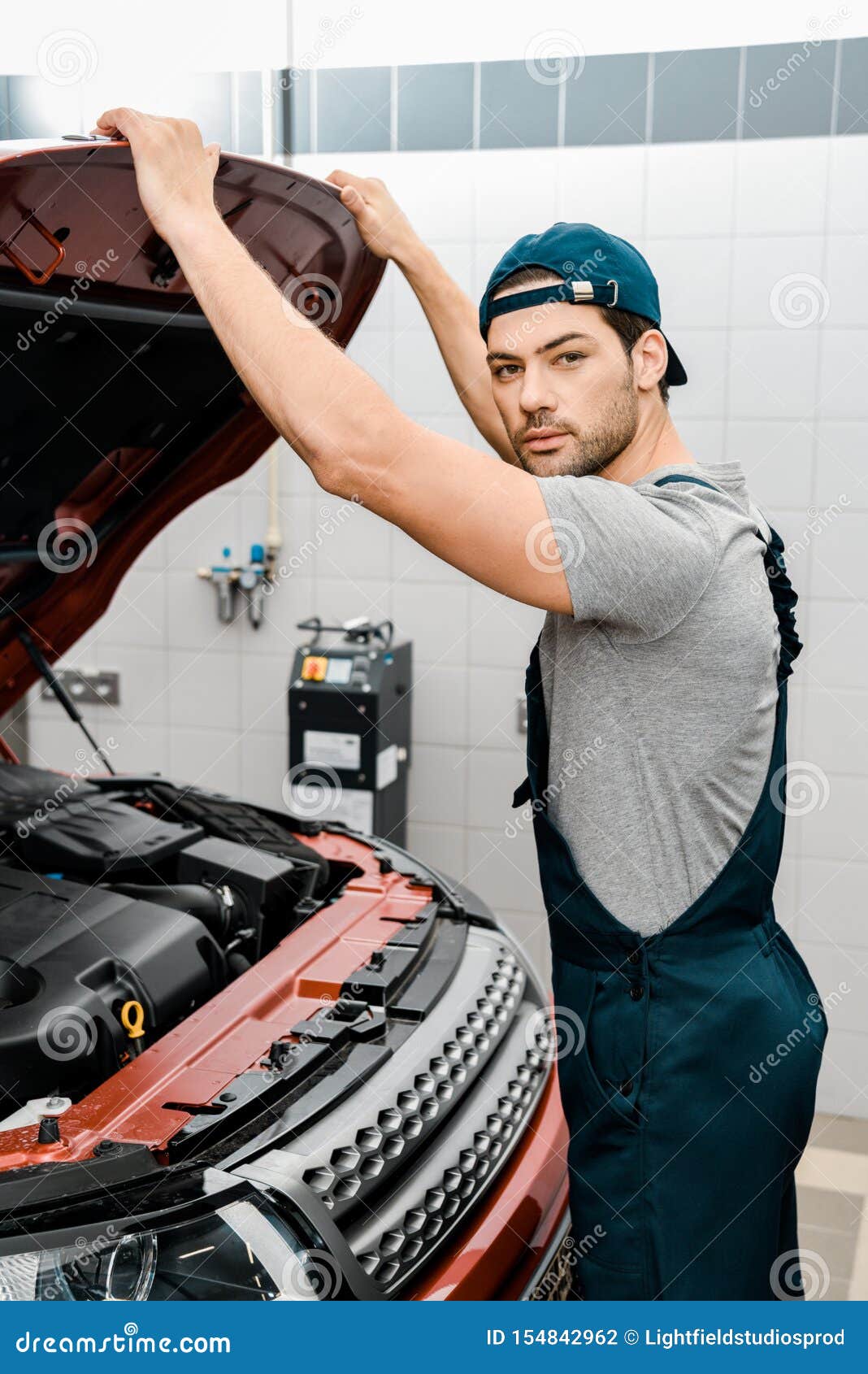 Auto Mechanic Looking at Camera while Examining Car Cowl Stock Photo ...