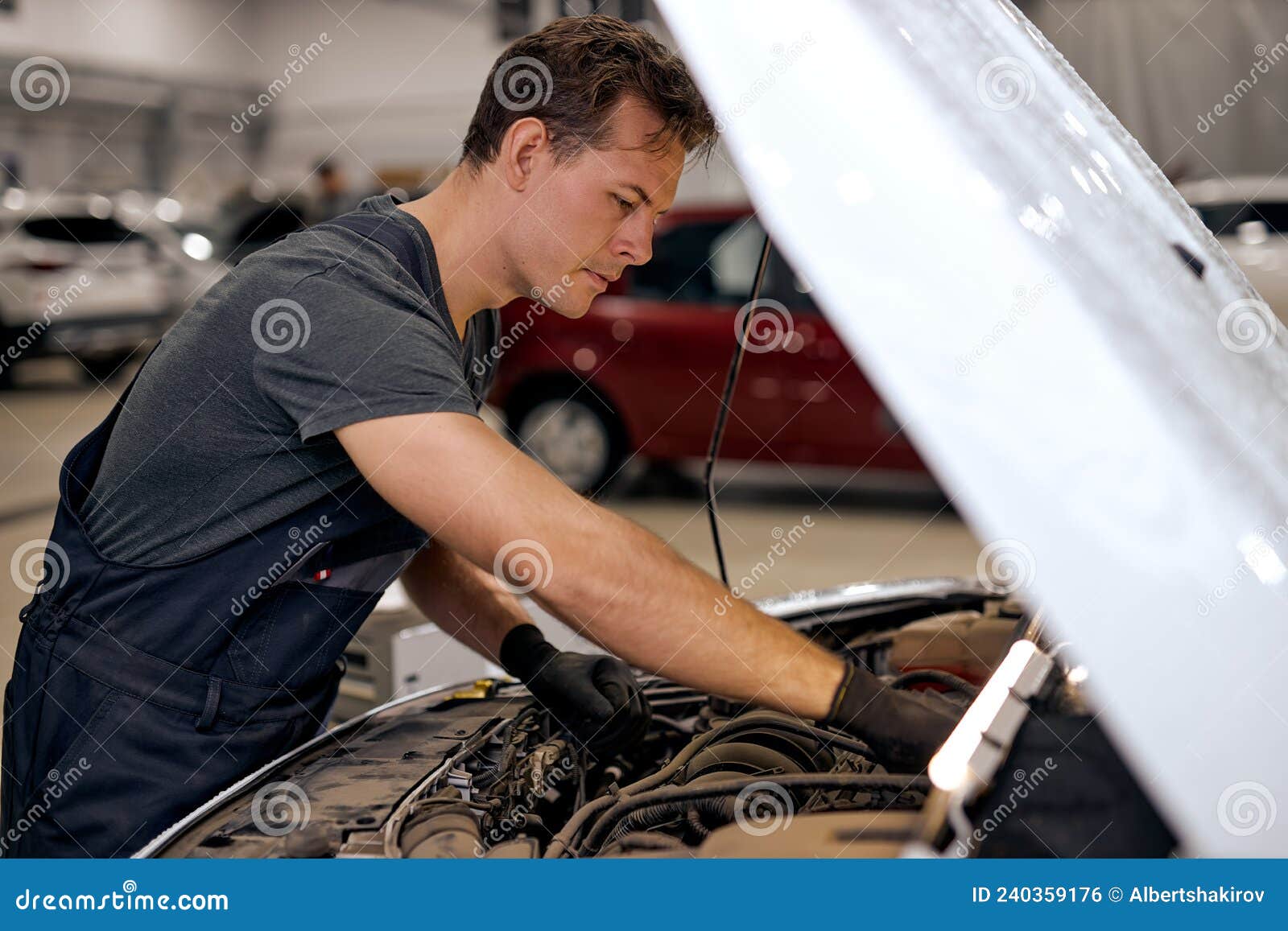 Auto Mechanic Looking Inside of Engine in Garage. Car Motor Repair ...