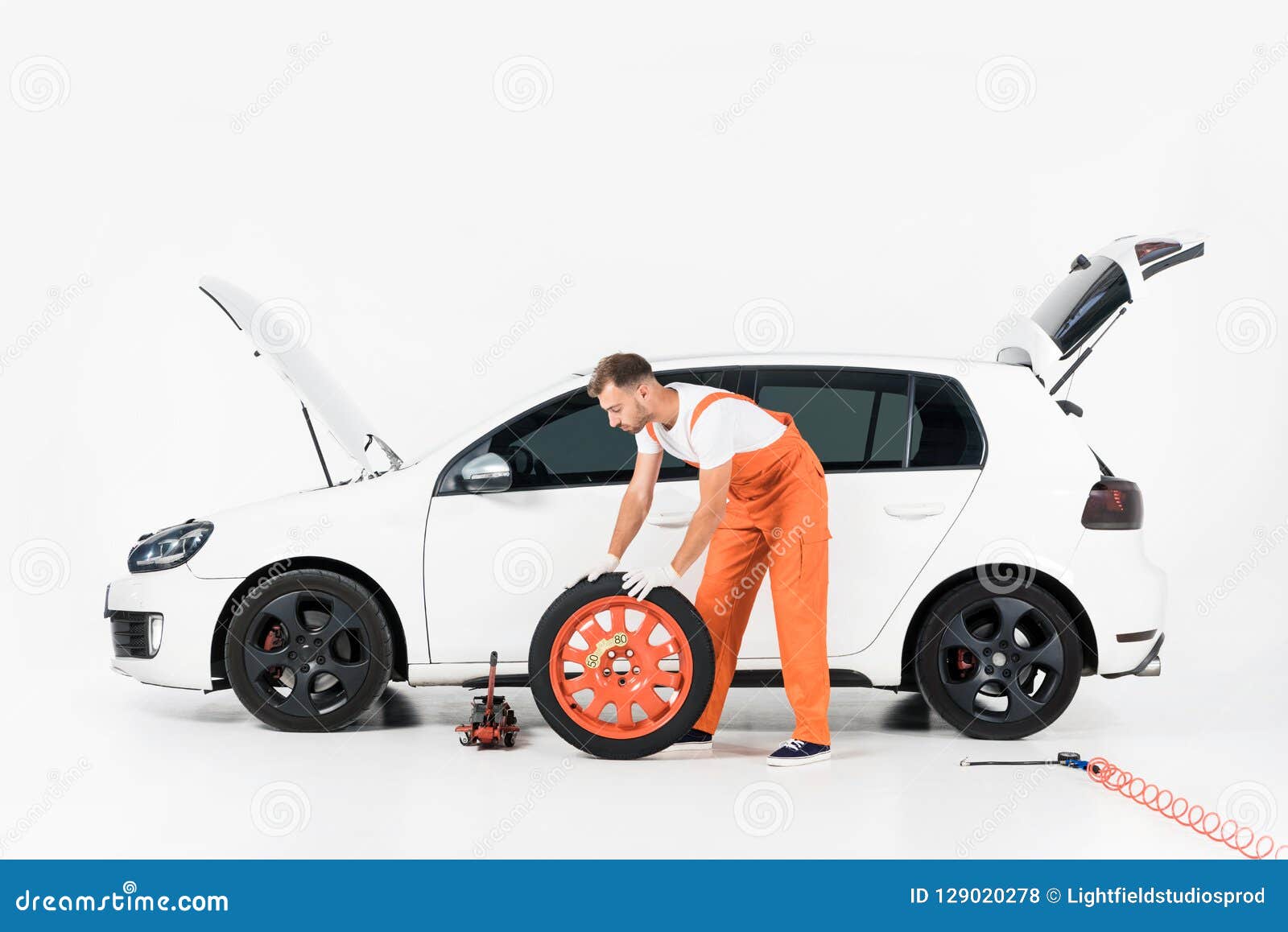 Auto Mechanic Pushing Car Tire Stock Photo - Image of handsome, alone ...