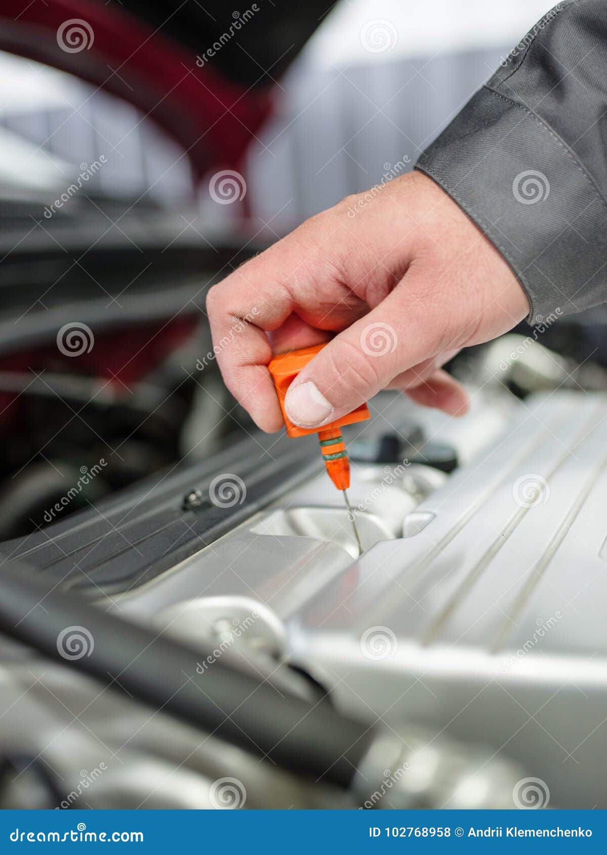 The Man Unscrews the Bolt with an Orange Screwdriver on the Engine ...