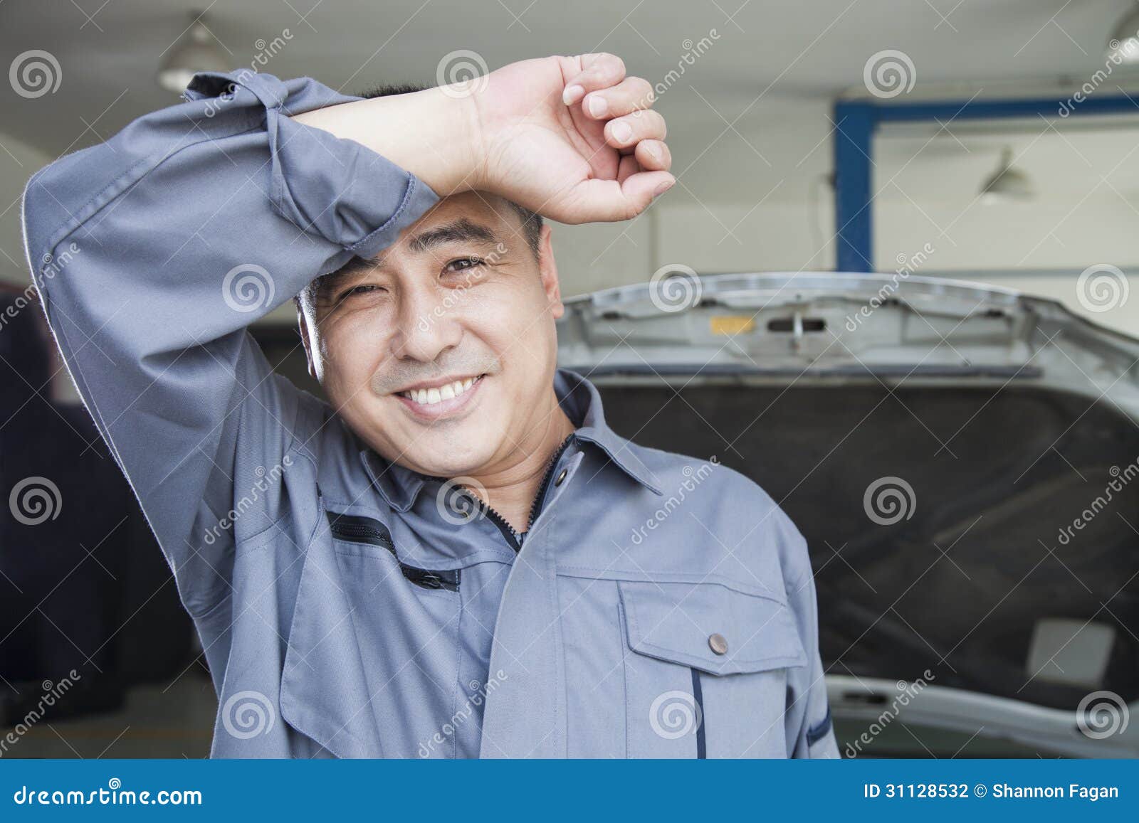 Auto Mechanic Wiping the Sweat Off His Brow, Smiling Stock Photo ...