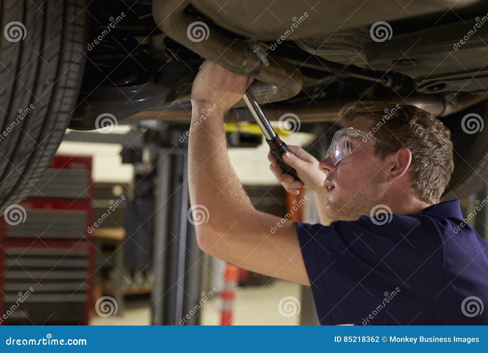 Auto Mechanic Working Underneath Car in Garage Stock Photo - Image of ...