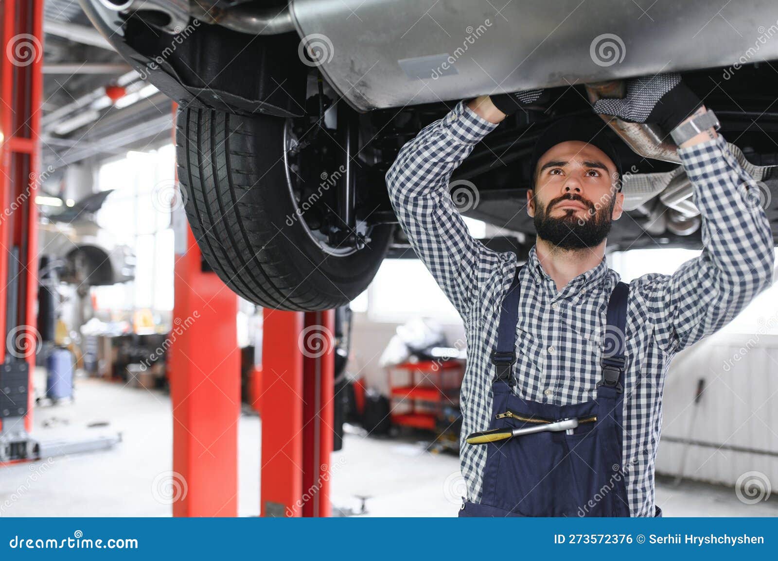 Auto Mechanic Working Underneath a Lifted Car Stock Photo - Image of ...