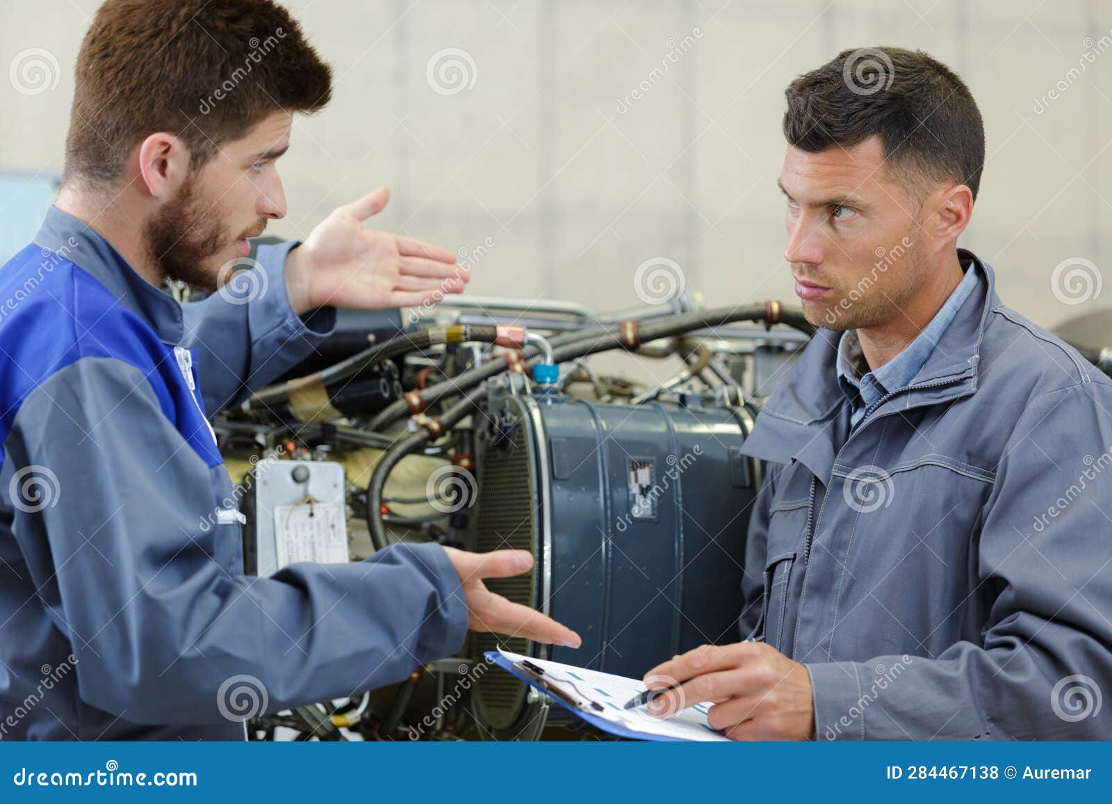 Auto Mechanics Discussing Document in Garage Stock Photo - Image of ...
