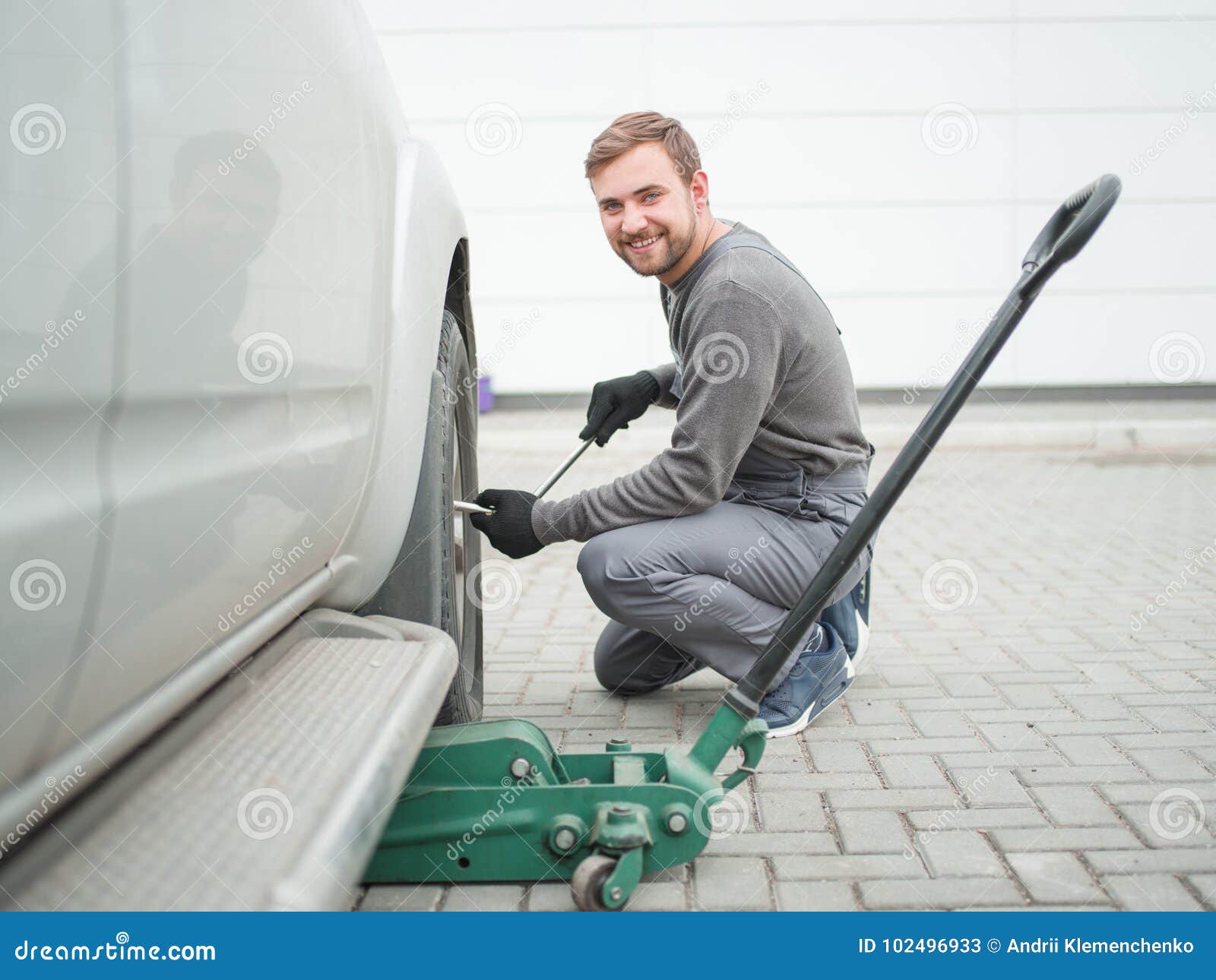The Auto-worker Changes the Wheel of the Machine and Smile. Outside ...
