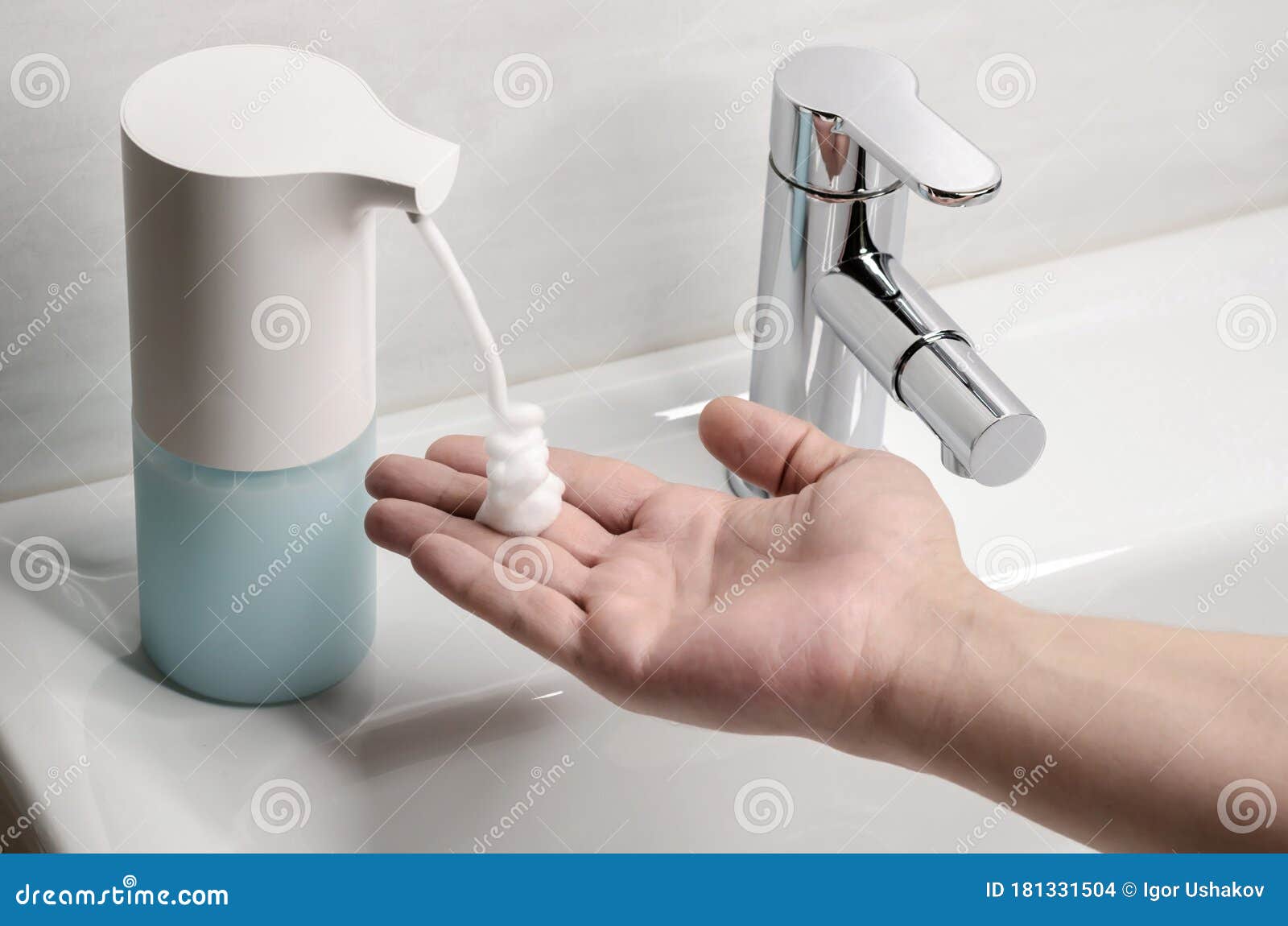 Automatic Soap Dispenser in the Bathroom. Hand with Soapy Solution ...