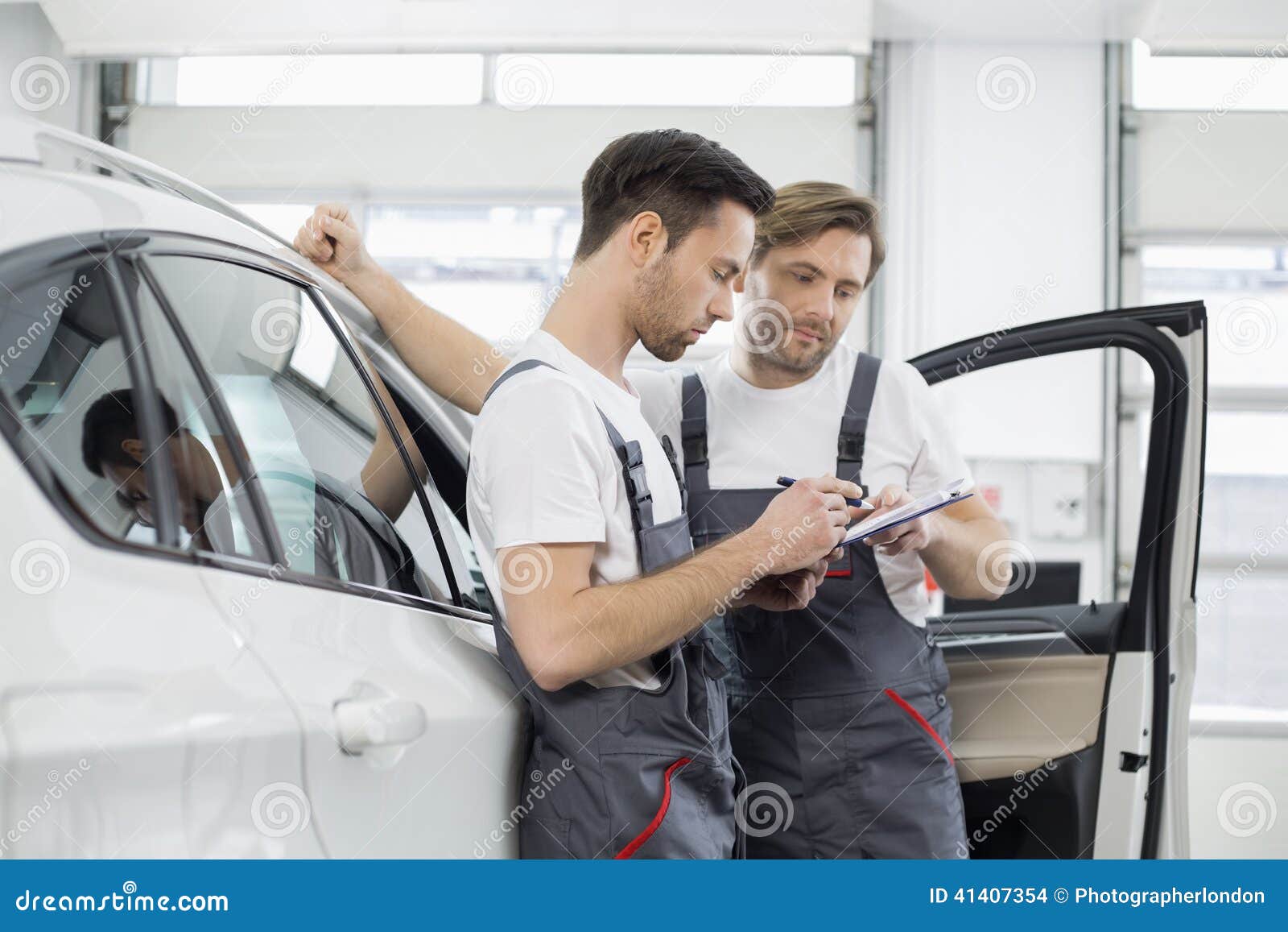 Automobile Mechanics Checking Checklist while Standing by Car in ...