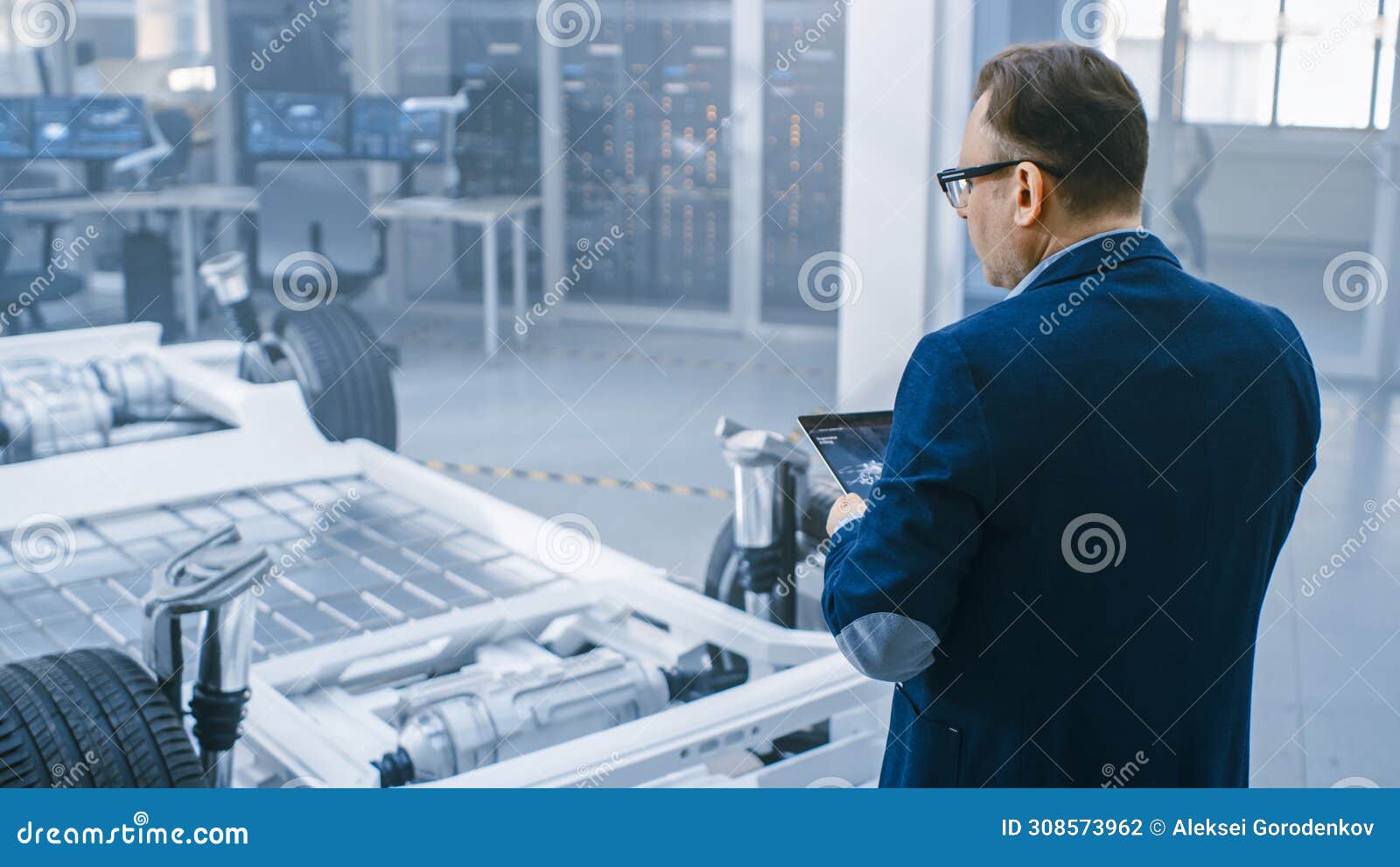 Automotive Design Engineer Looking at Technical Drawing of an Electric ...