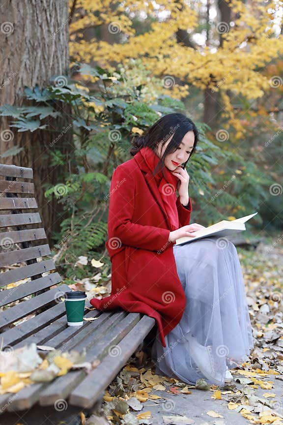 Young Asian Sensual Woman Reading A Book Sit Bench In Romantic Autumn