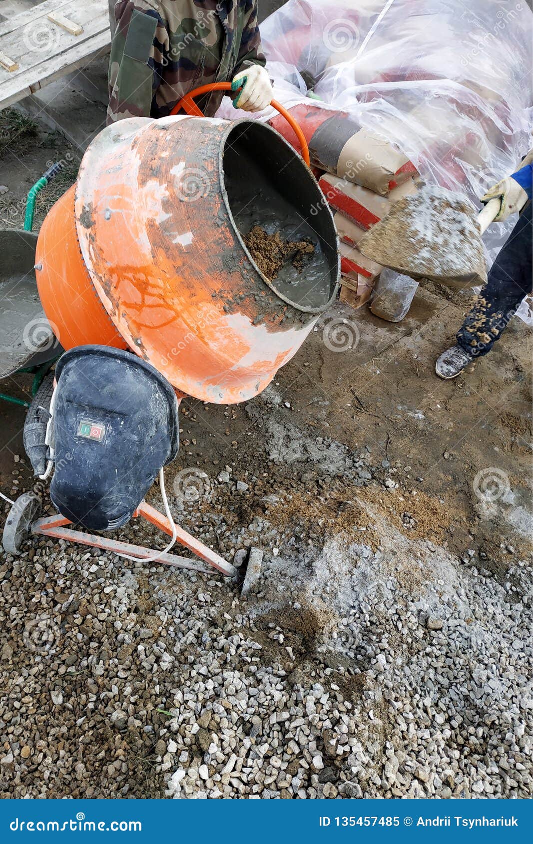 Auxiliary Worker Develops a Cement Mortar in a Concrete Mixer at the ...