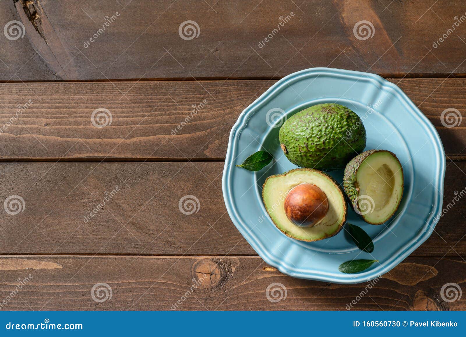 Avocado in plate on table stock photo. Image of plank - 160560730