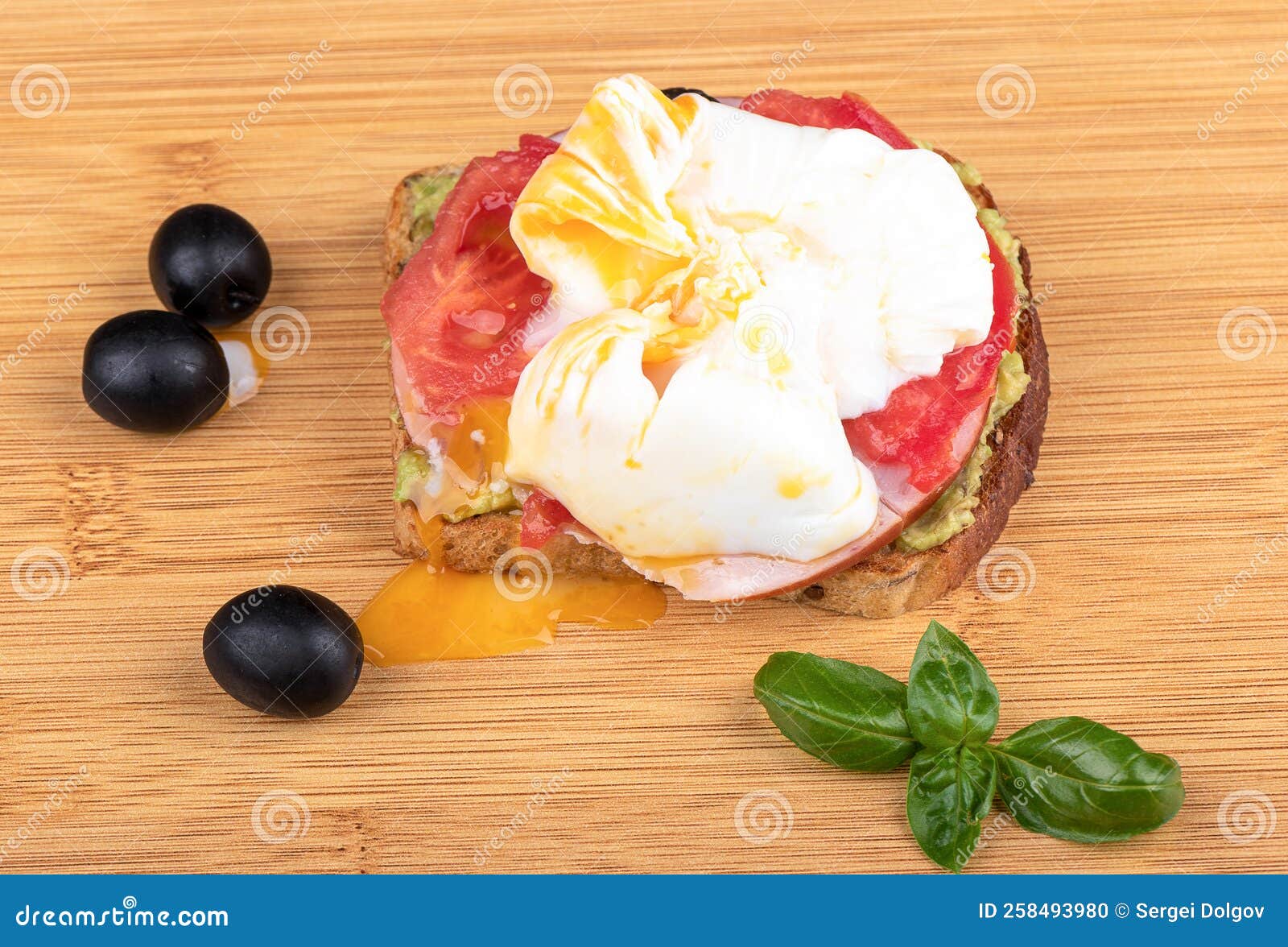 Avocado Toast with Melted Poached Egg Yolk on a Cutting Board. Stock ...
