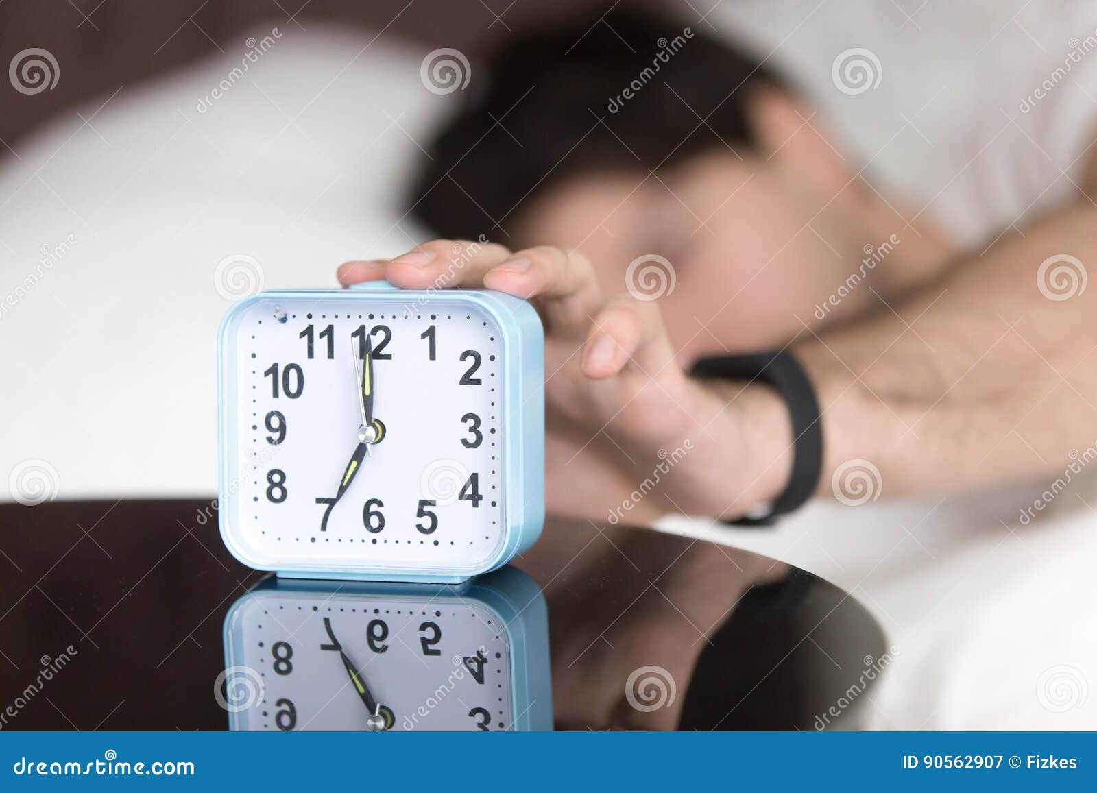 Awakingsmens In Bed Die Manchet Dragen Die Wekker Uitzetten Stock
