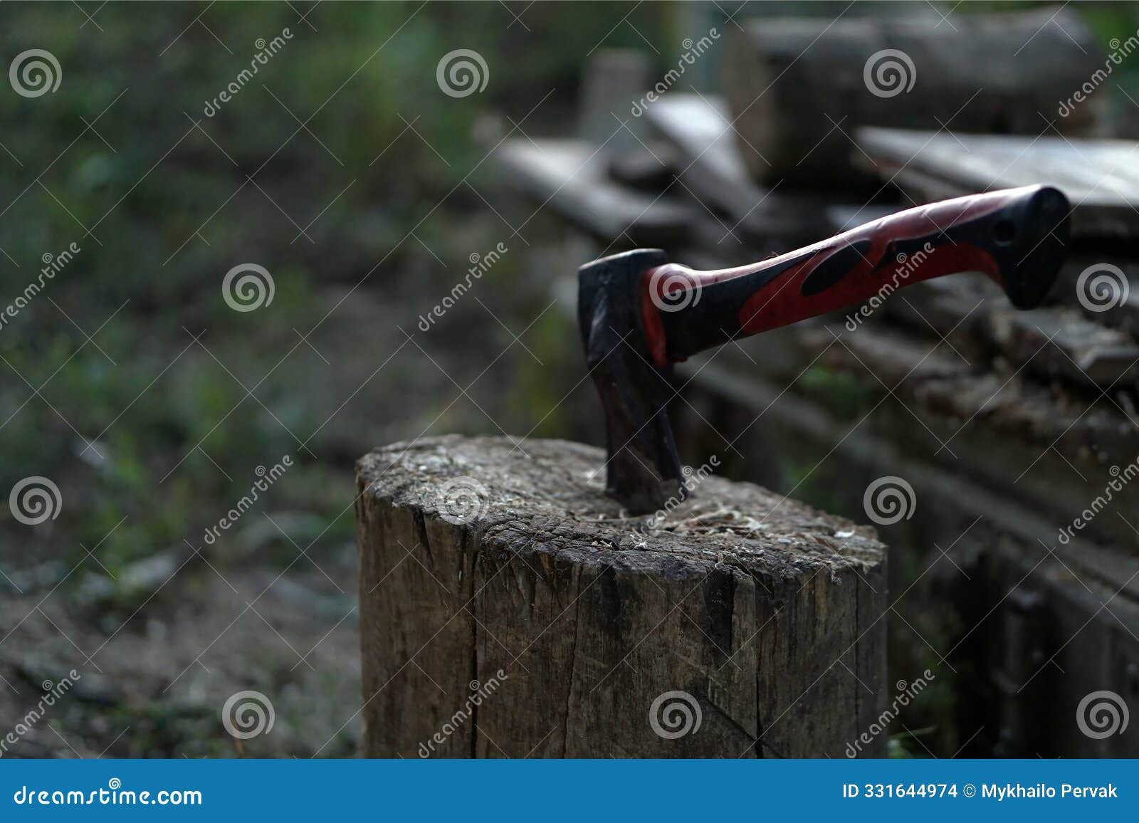 An Axe with a Rubber Handle is Stuck in a Wooden Log. Logging on the ...
