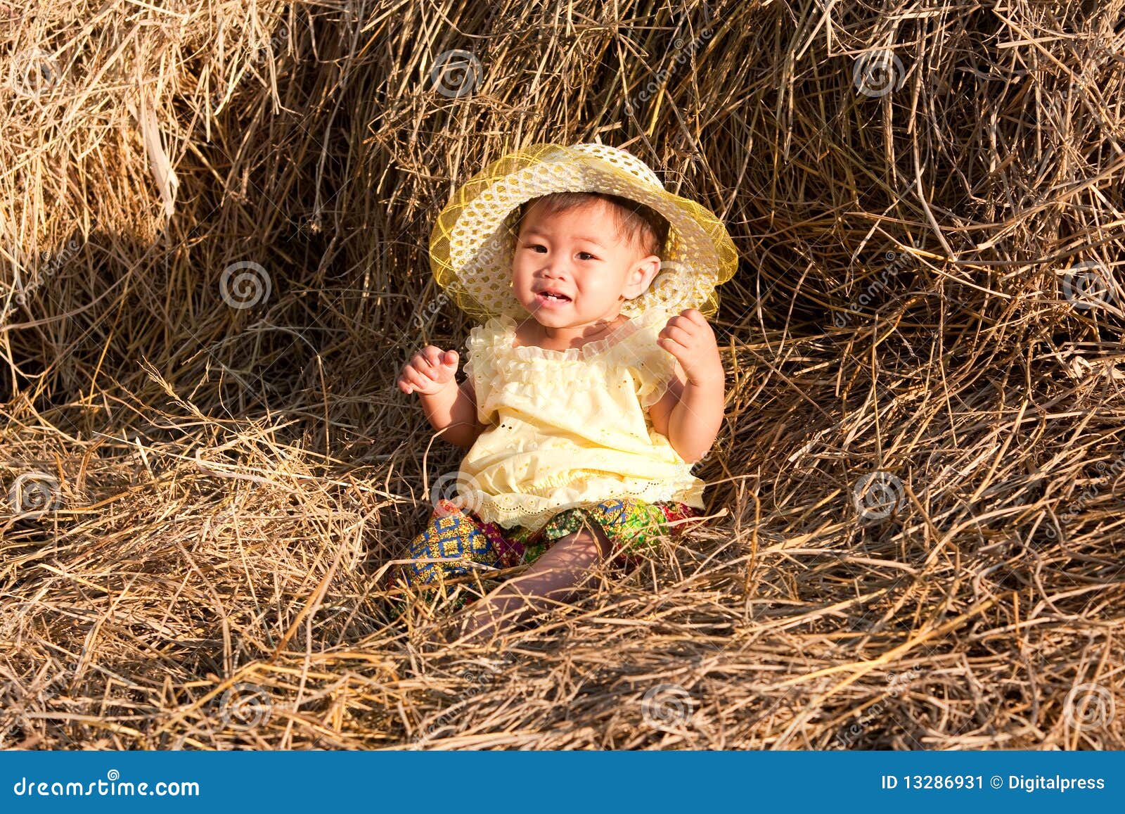 Baby of Asia sits in straw stock image. Image of girl - 13286931
