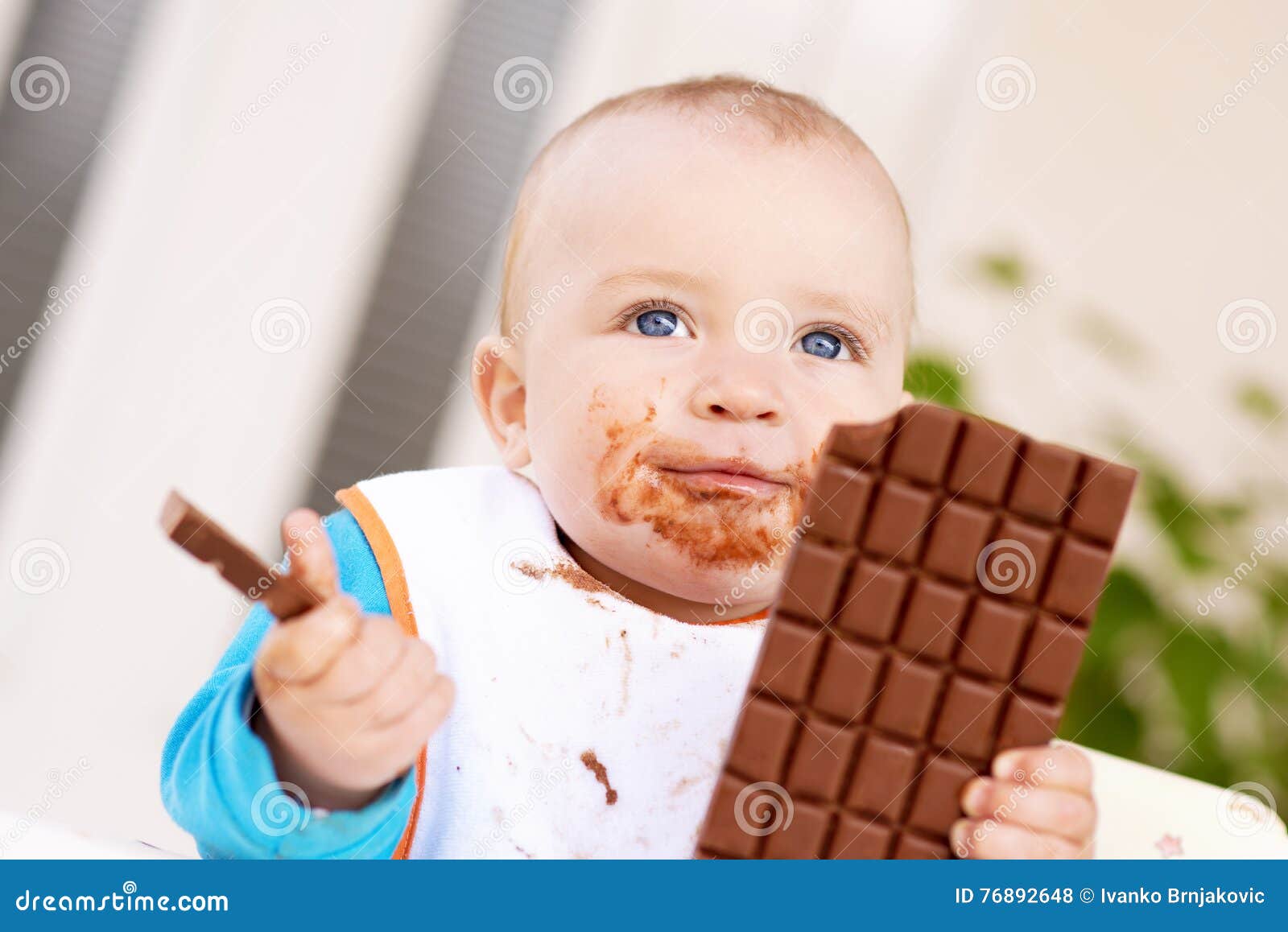 Baby boy eating chocolate stock photo. Image of child - 76892648