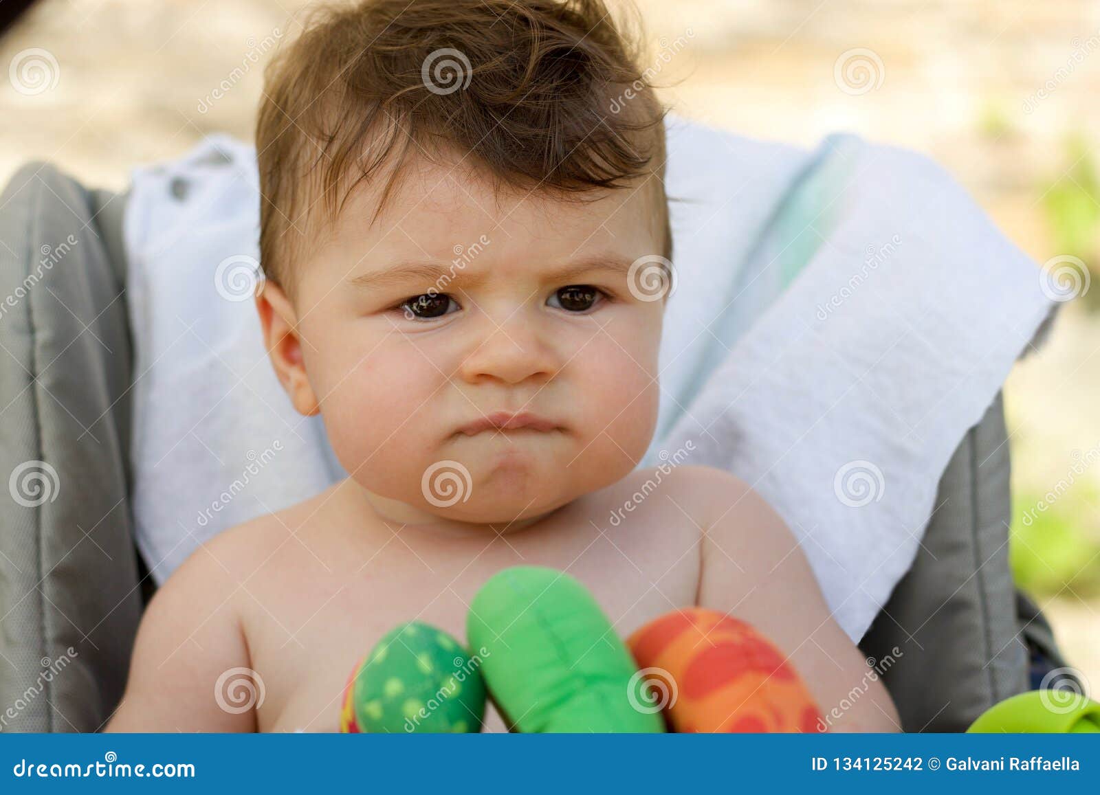 Baby Boy Sitting on a Stroller with Sulky Expression Stock Photo ...
