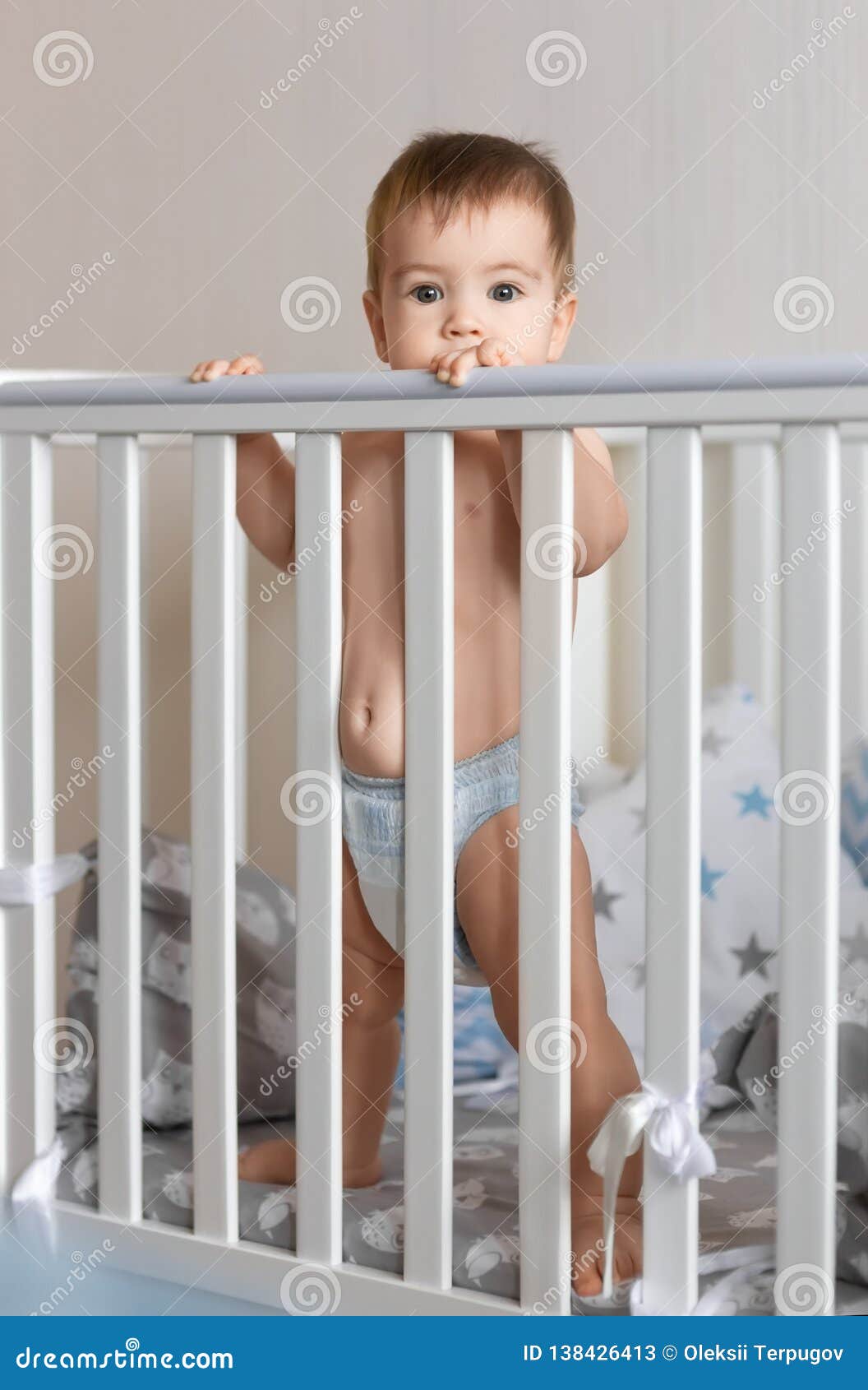 Baby boy standing in crib stock image. Image of active - 138426413