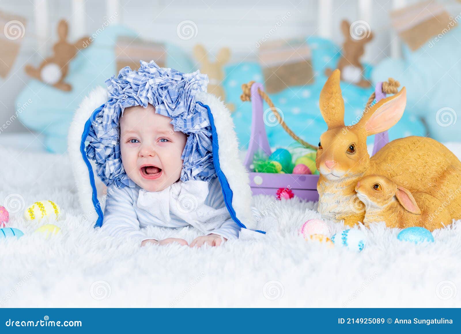 Baby in a Bunny Hat Crying on a Bed with Easter Eggs and Rabbits ...