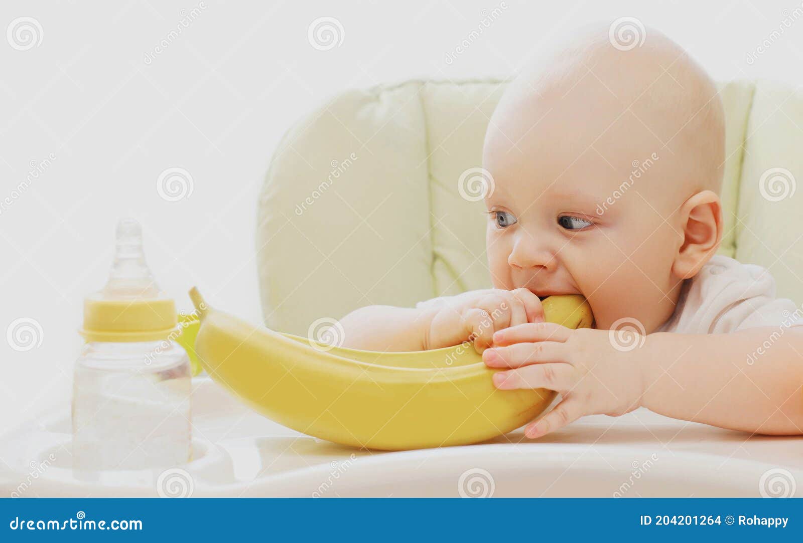 Baby Eating Banana Sitting at the Table at Home Stock Photo - Image of ...