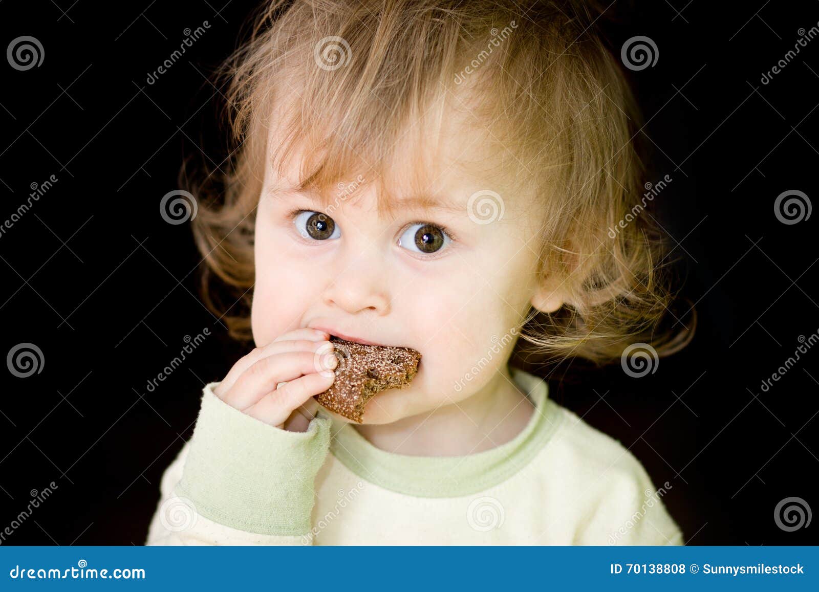 Baby eating bread stock photo. Image of female, person - 70138808