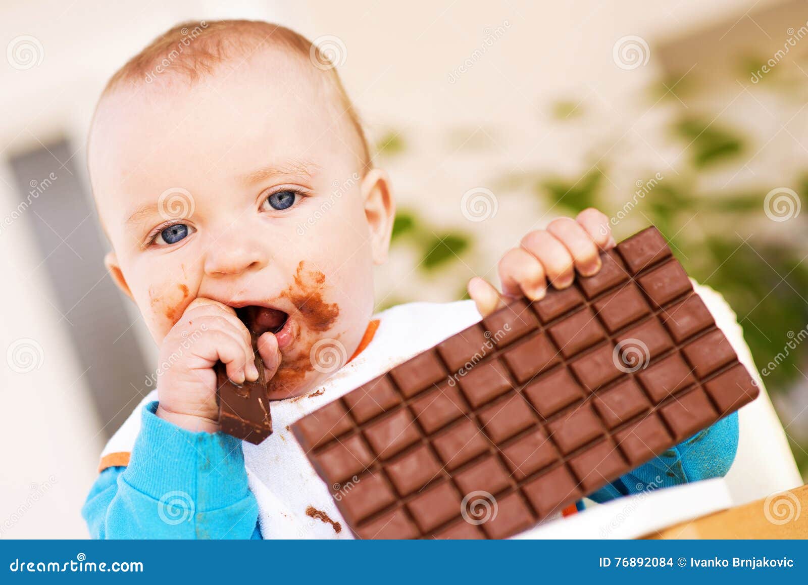 Baby eating chocolate stock photo. Image of smiling, comfortable - 76892084
