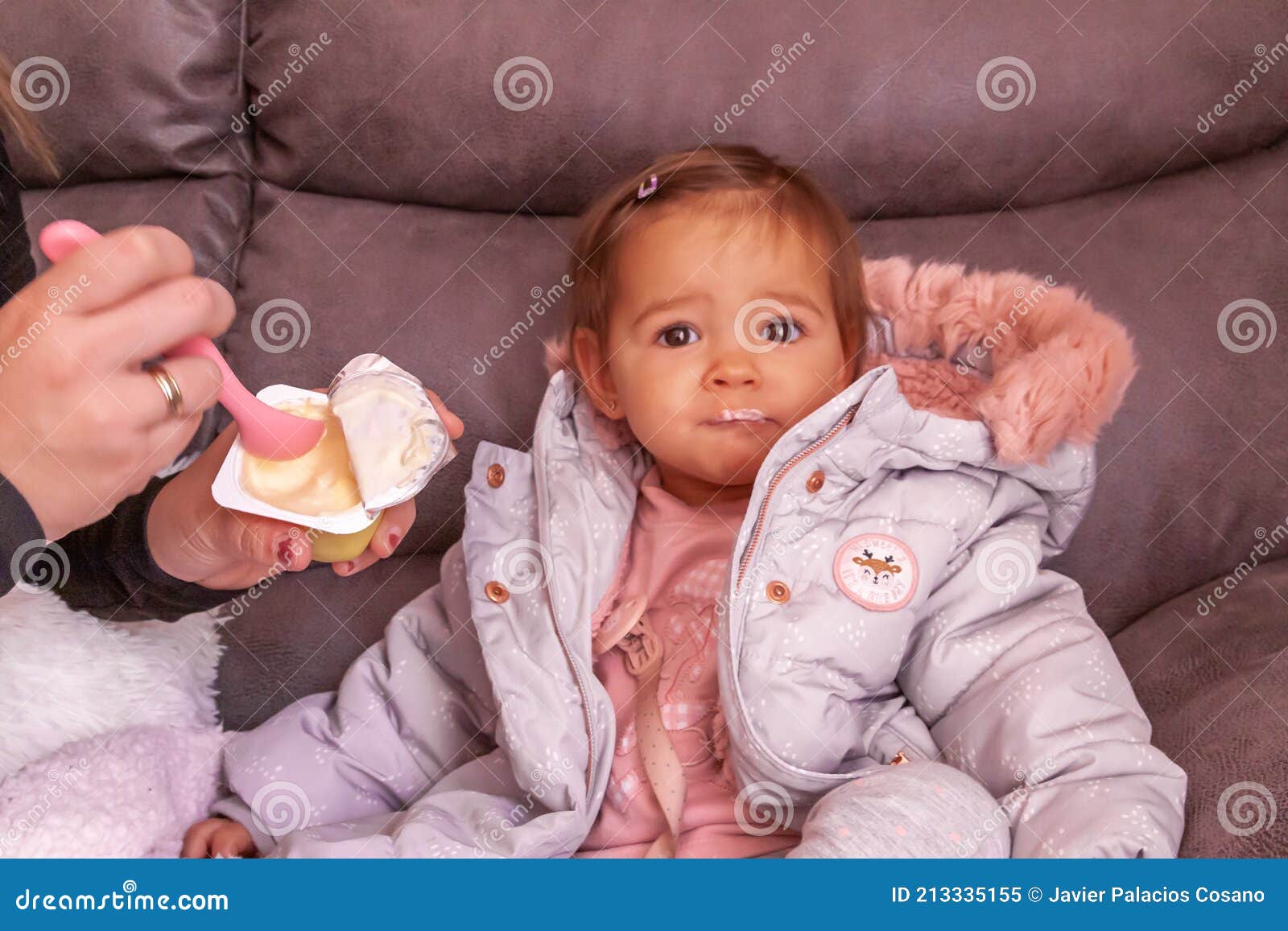 Baby Eating Yoghurt on the Sofa Stock Image - Image of looking ...