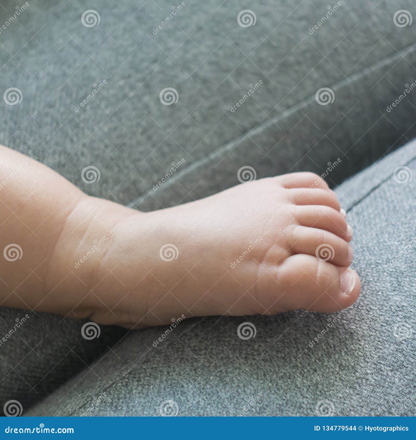 Baby foot on a gray sofa stock photo. Image of massage - 134779544