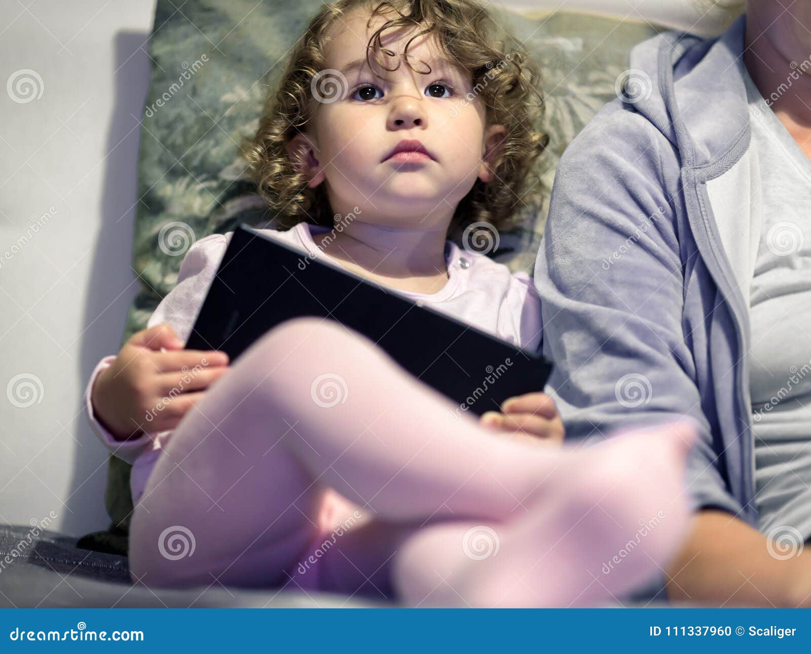Baby Girl Sits Near Her Mother and Uses a Digital Tablet Stock Photo ... Baby Girl Sits Near Her Mother and Uses a Digital Tablet Stock Photo ...