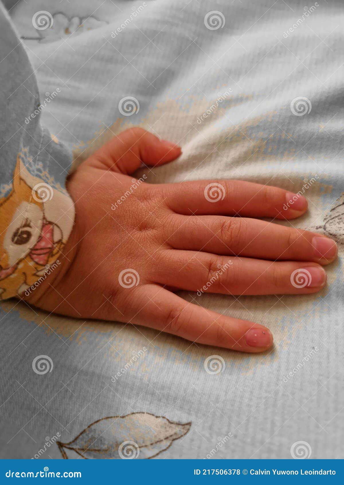Baby hand on the bed stock photo. Image of finger, writing - 217506378