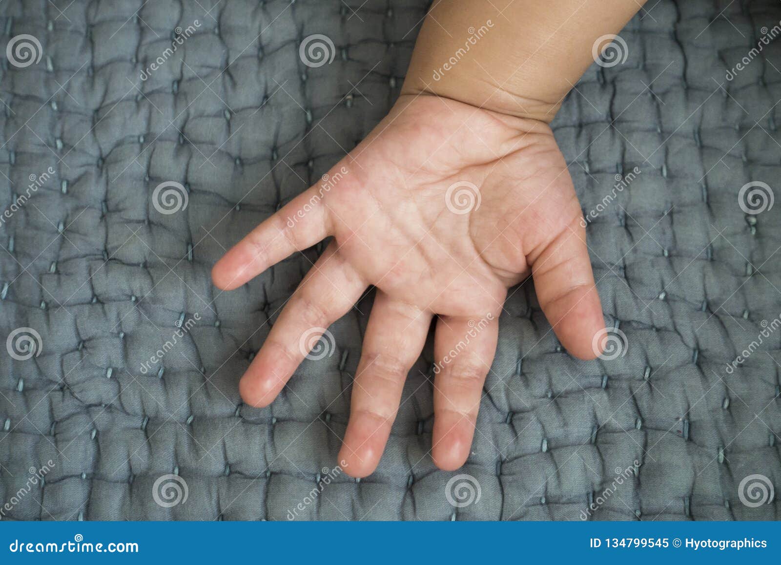 Baby hand on a gray sofa stock image. Image of love - 134799545