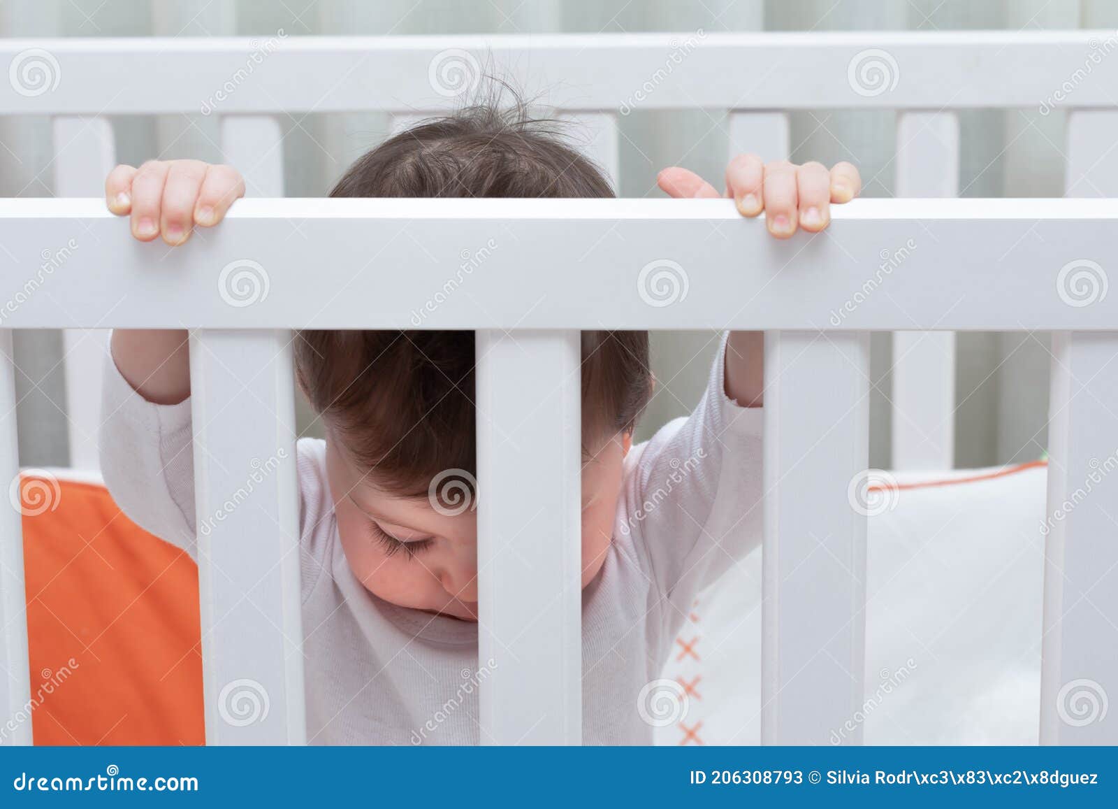 Baby Inside a Cradle Holding the Bars and Looking Down Stock Image ...