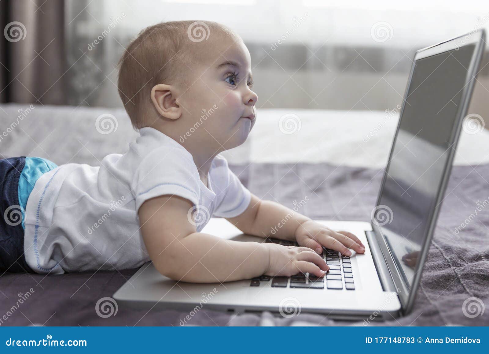 The Baby Looks with Interest at the Laptop Screen. New Generation Stock ...