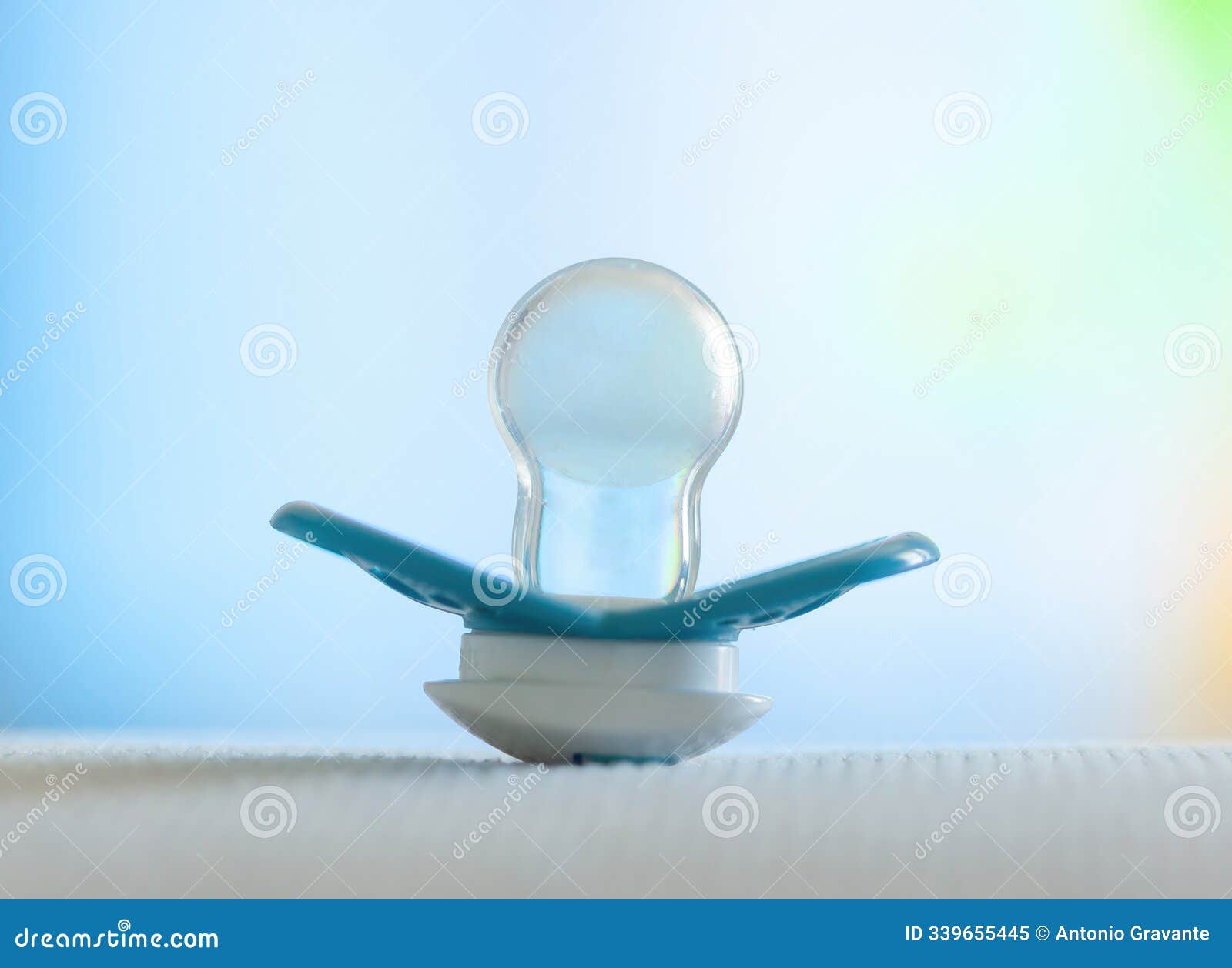 Baby Pacifier Standing on a White Surface with Blue Background Stock ...