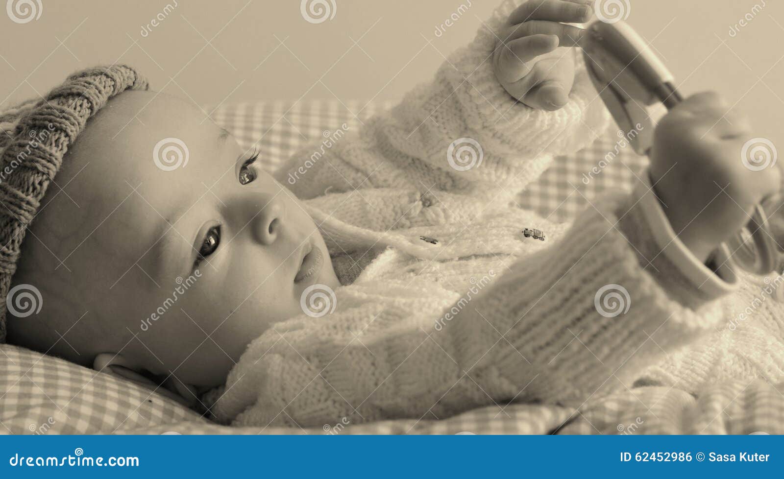 Baby is Playing with a Rattle Stock Photo - Image of black, pillow ...